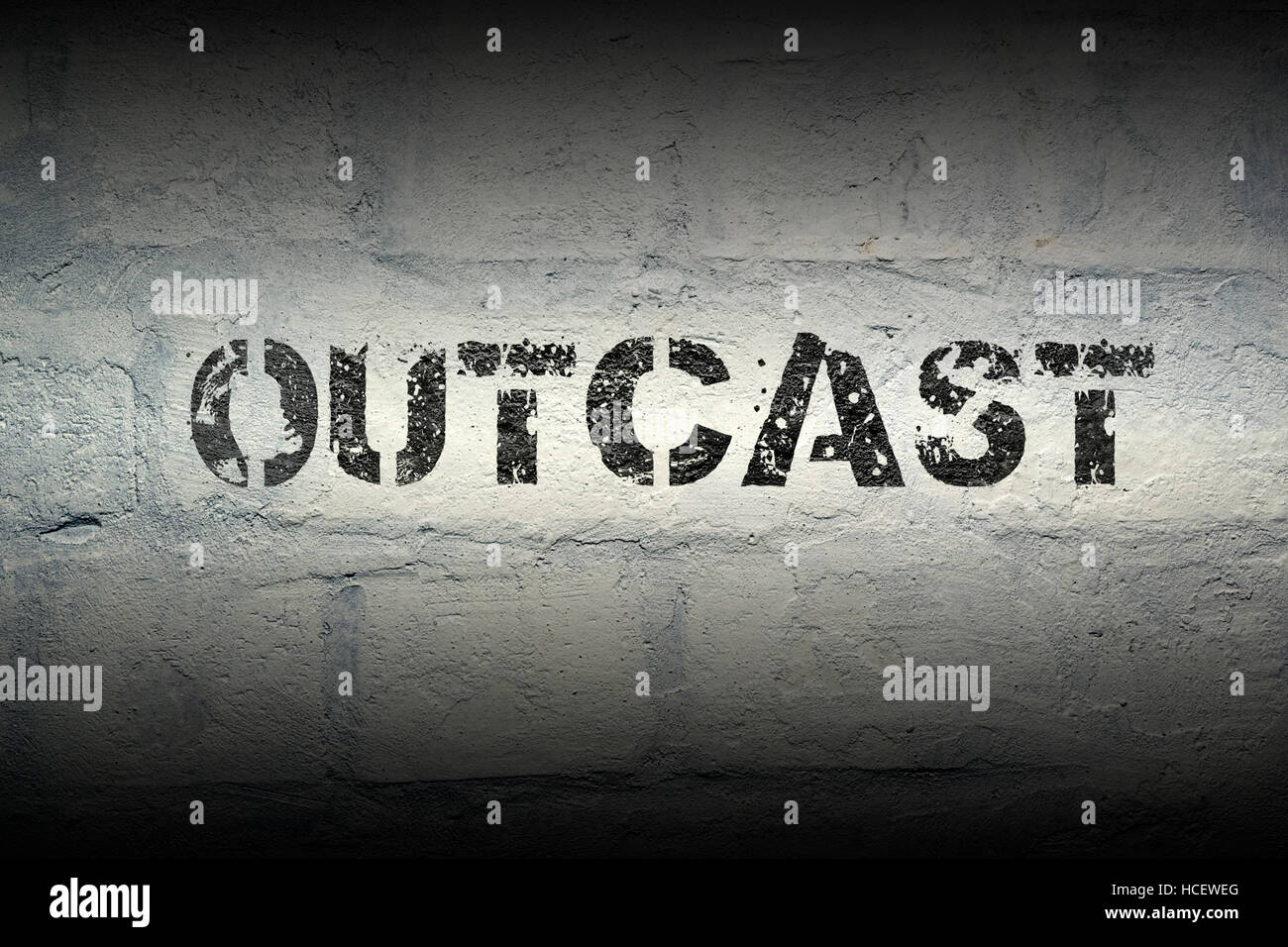 outcast word stencil print on the grunge white brick wall Stock Photo ...