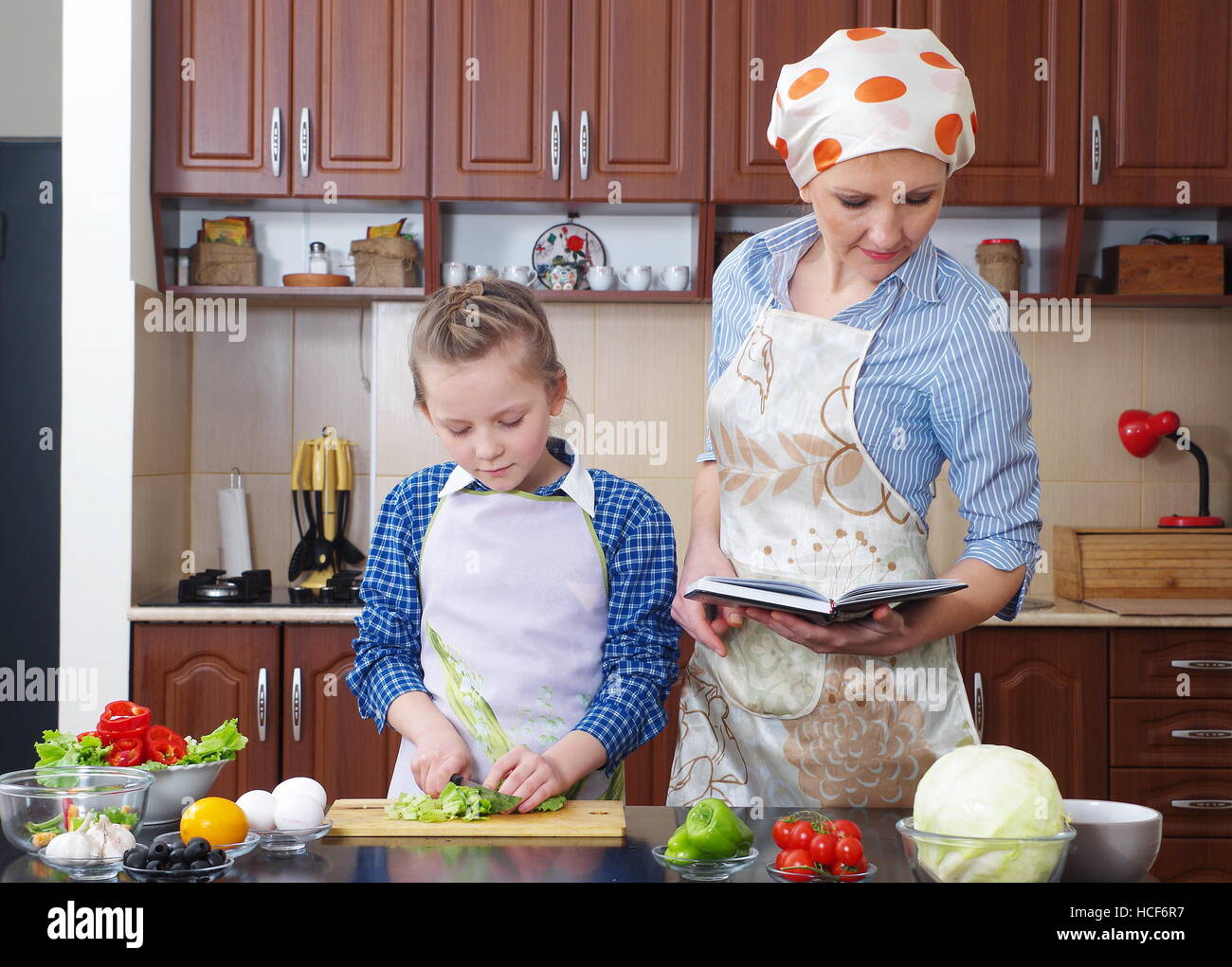 little girl is teaching her mother to cook in a kitchen with different ...