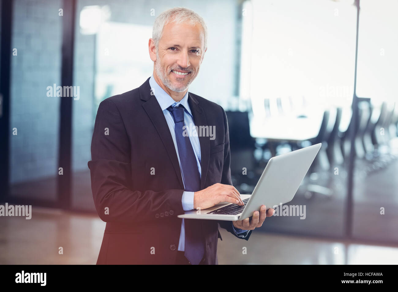 Portrait of businessman using laptop in office Stock Photo - Alamy