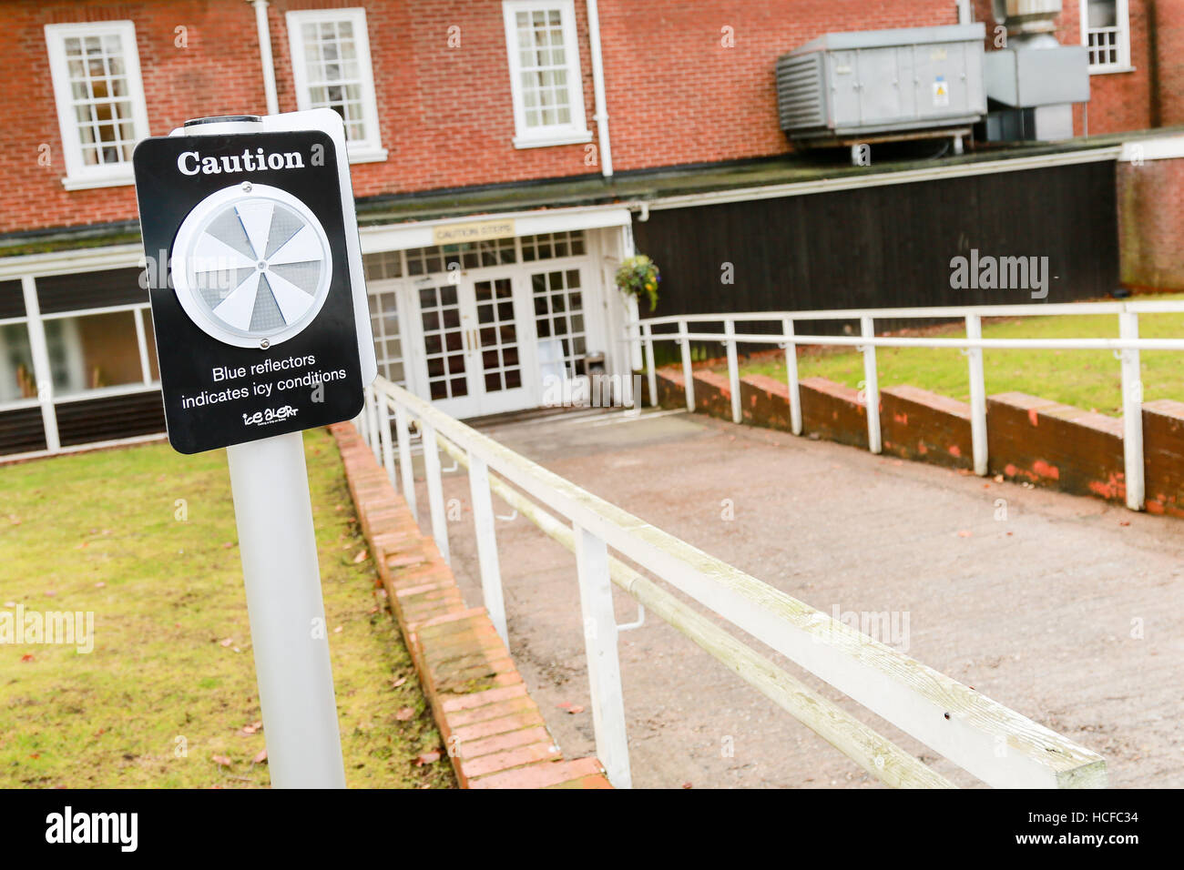 A high tech sign warning about icy conditions on a sloping surface ...