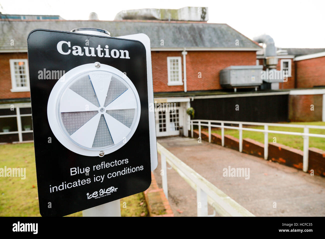 A high tech sign warning about icy conditions on a sloping surface ...