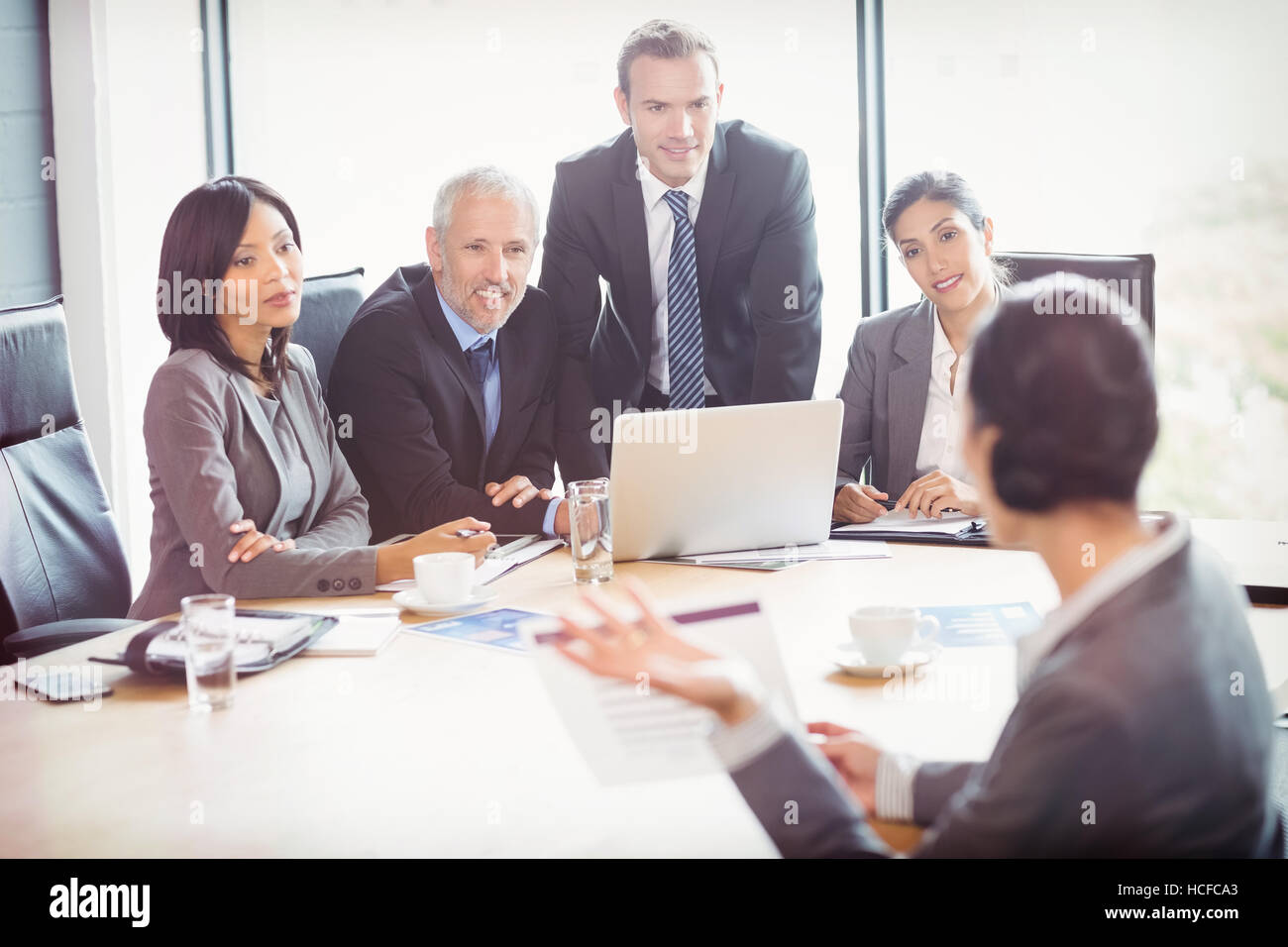 Businesspeople interacting in conference room Stock Photo - Alamy