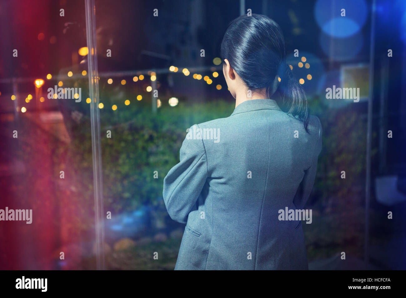 Businesswoman looking through window Stock Photo - Alamy