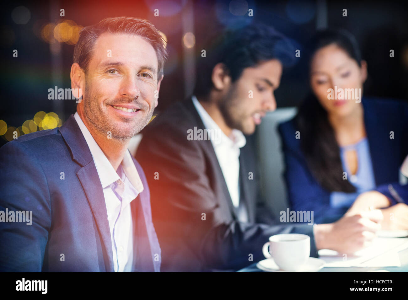 Businessman smiling while colleagues interacting Stock Photo - Alamy Businessman smiling while colleagues interacting Stock Photo - Alamy