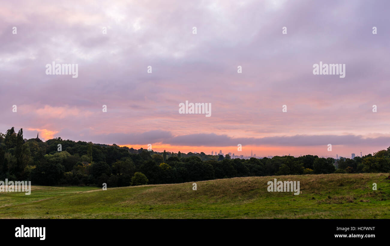Orange skies at dawn over the London skyline from Hampstead Heath ...