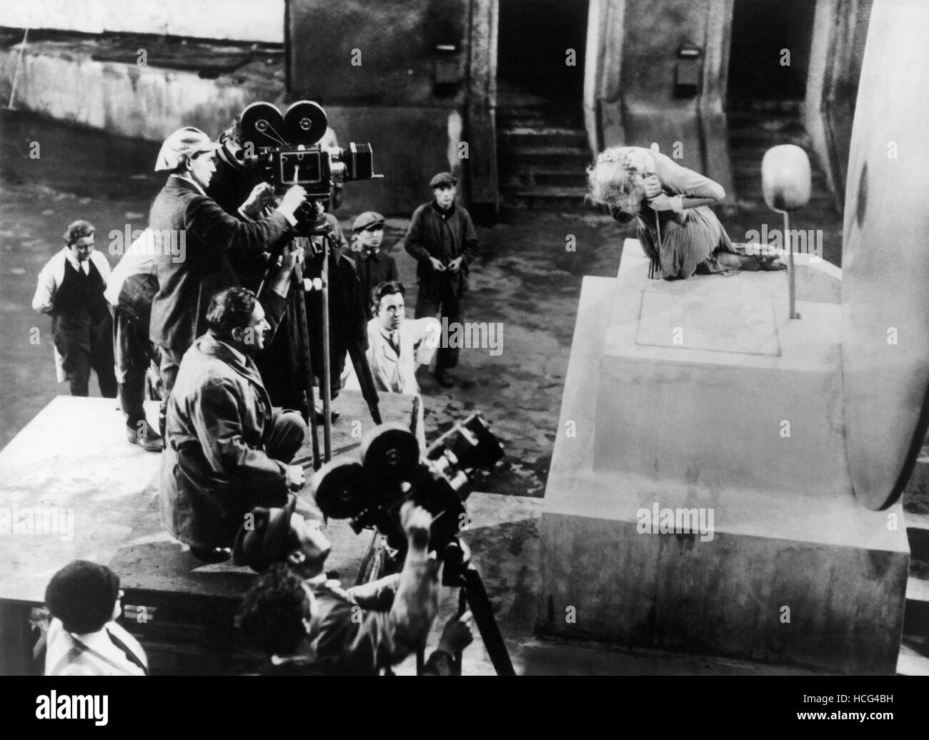 METROPOLIS, director Fritz Lang (kneeling) and crew filming Brigitte Helm (right) on set, 1927 ...