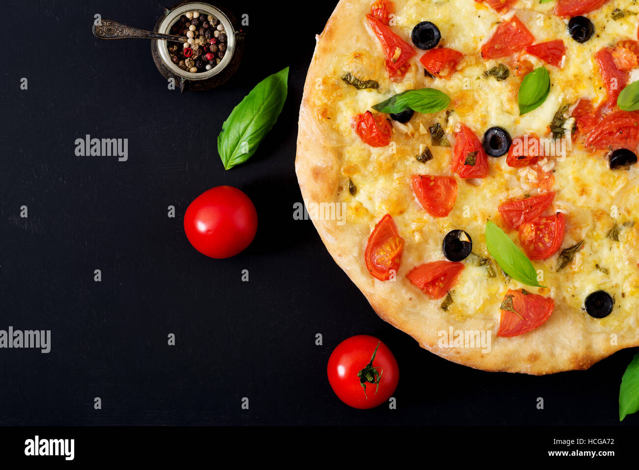Pizza with tomato, mozzarella, basil and olives. Top view Stock Photo ...