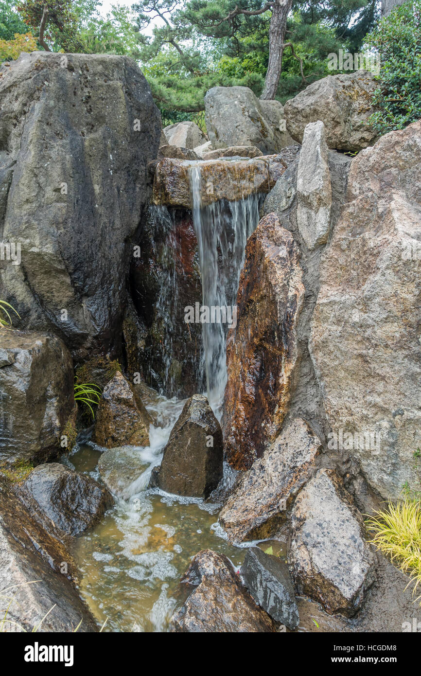 Water flows over a rock ledge creating a small waterfall somewhere in ...