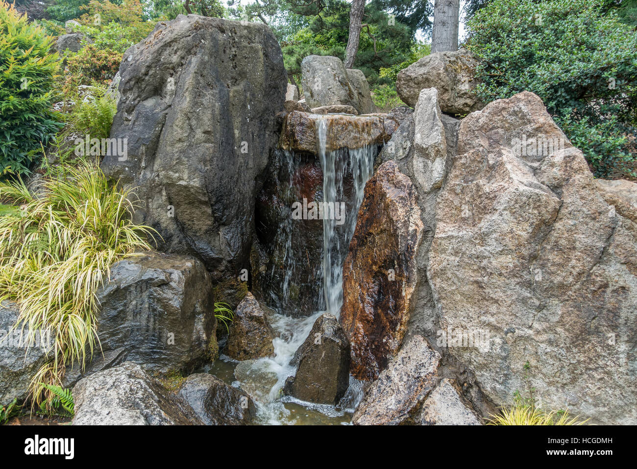 Water flows over a rock ledge creating a small waterfall somewhere in ...
