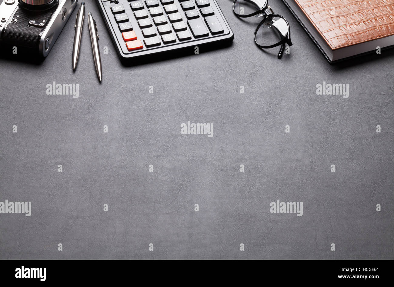 Office leather desk table with camera, supplies and glasses. View with ...