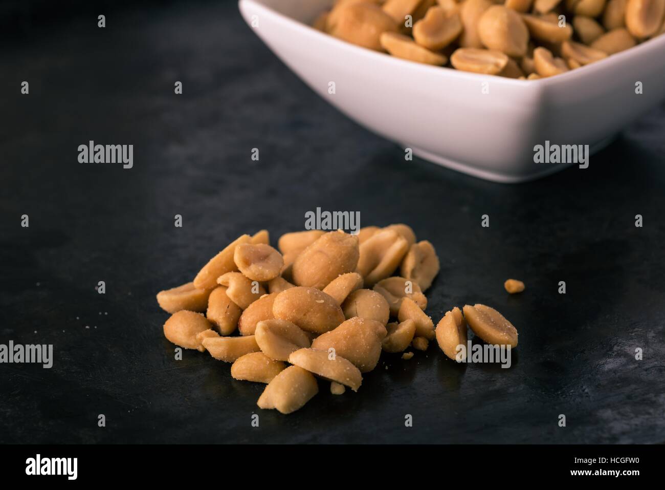 Horizontal photo of salted peanuts. Light brown nuts with salt placed ...
