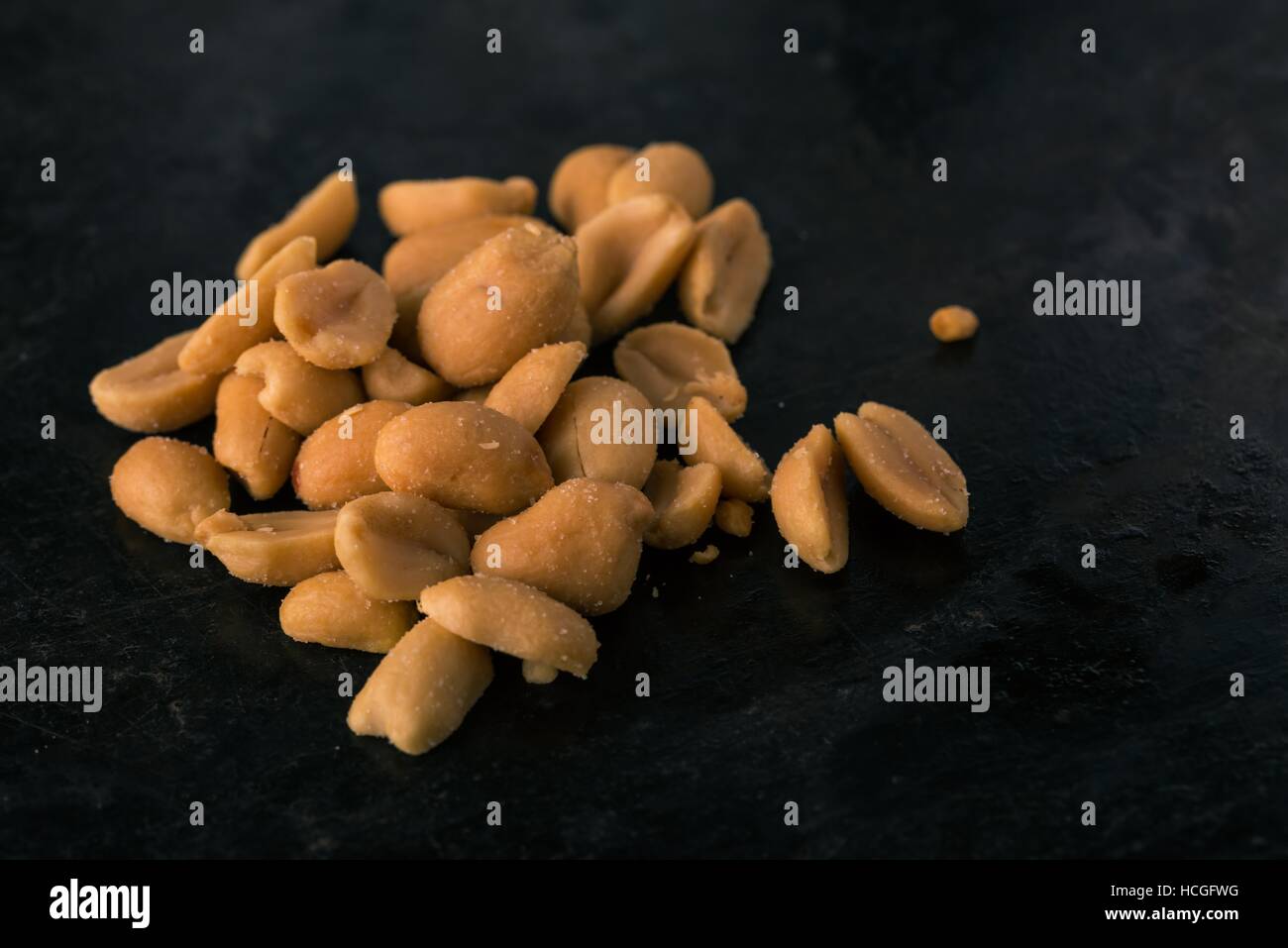 Horizontal photo of salted peanuts. Light brown nuts with salt placed ...