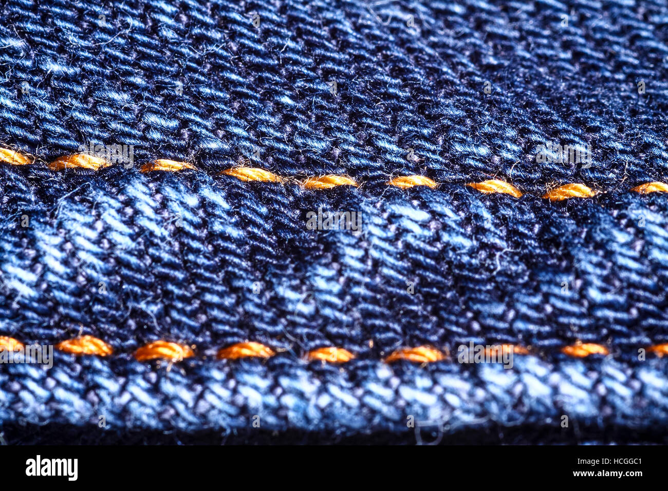 Close up view of blue woven cotton denim jean material and seam ...