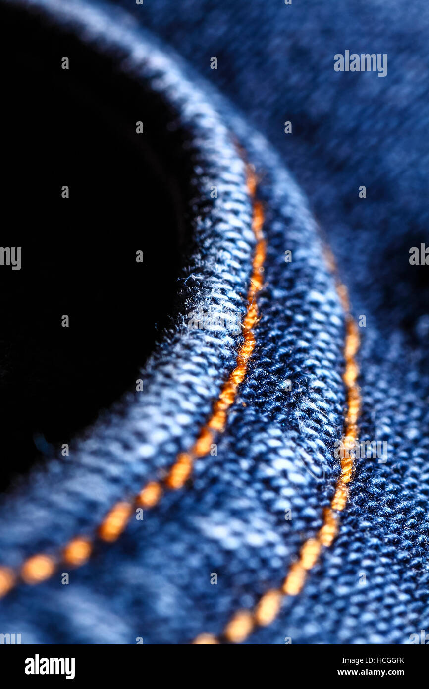 Close up view of blue woven cotton denim jean material and seam ...