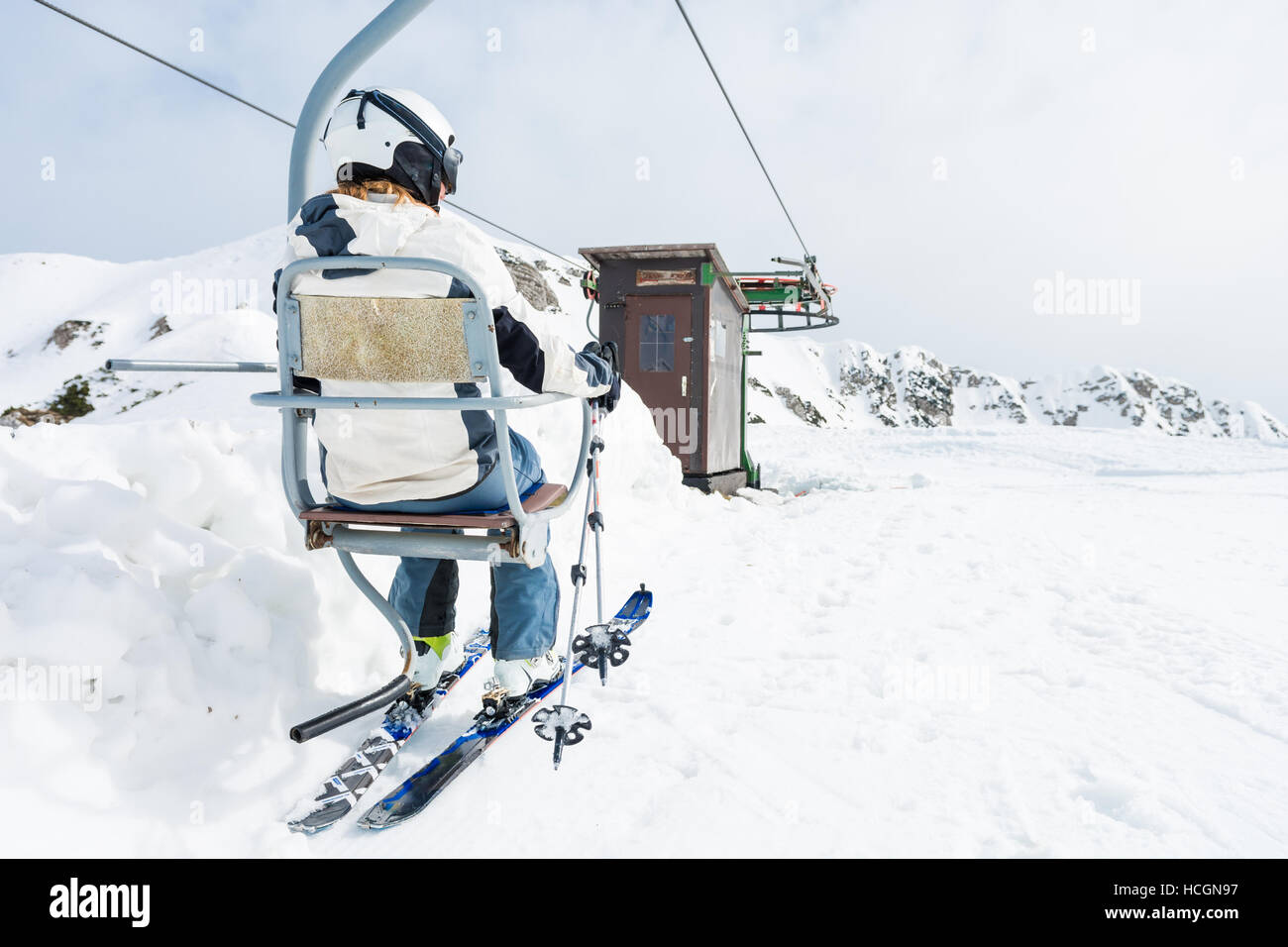 Back view of skier riding a lift Stock Photo - Alamy