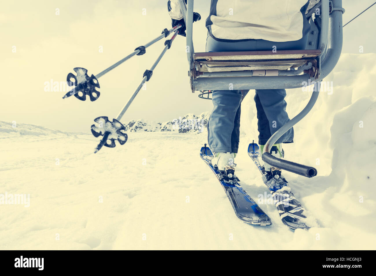 Back view of skier riding a lift Stock Photo - Alamy