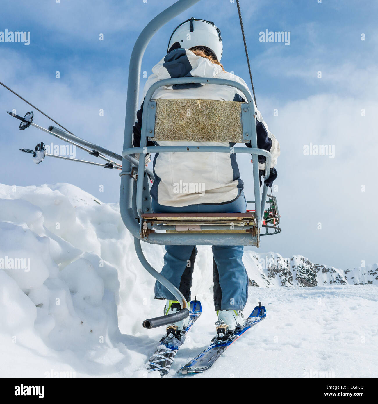 Back view of skier riding a lift Stock Photo - Alamy