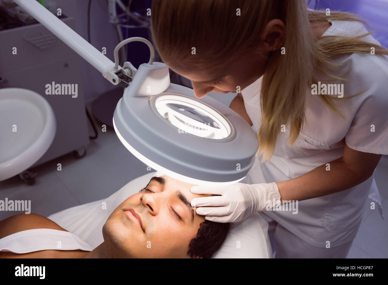 Doctor examining mans face for cosmetic treatment Stock Photo - Alamy