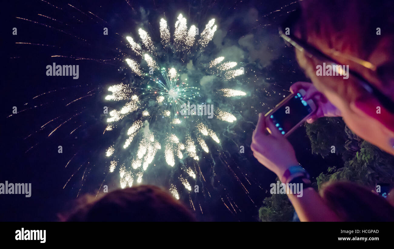 Woman photographing fireworks celebration with phone Stock Photo - Alamy