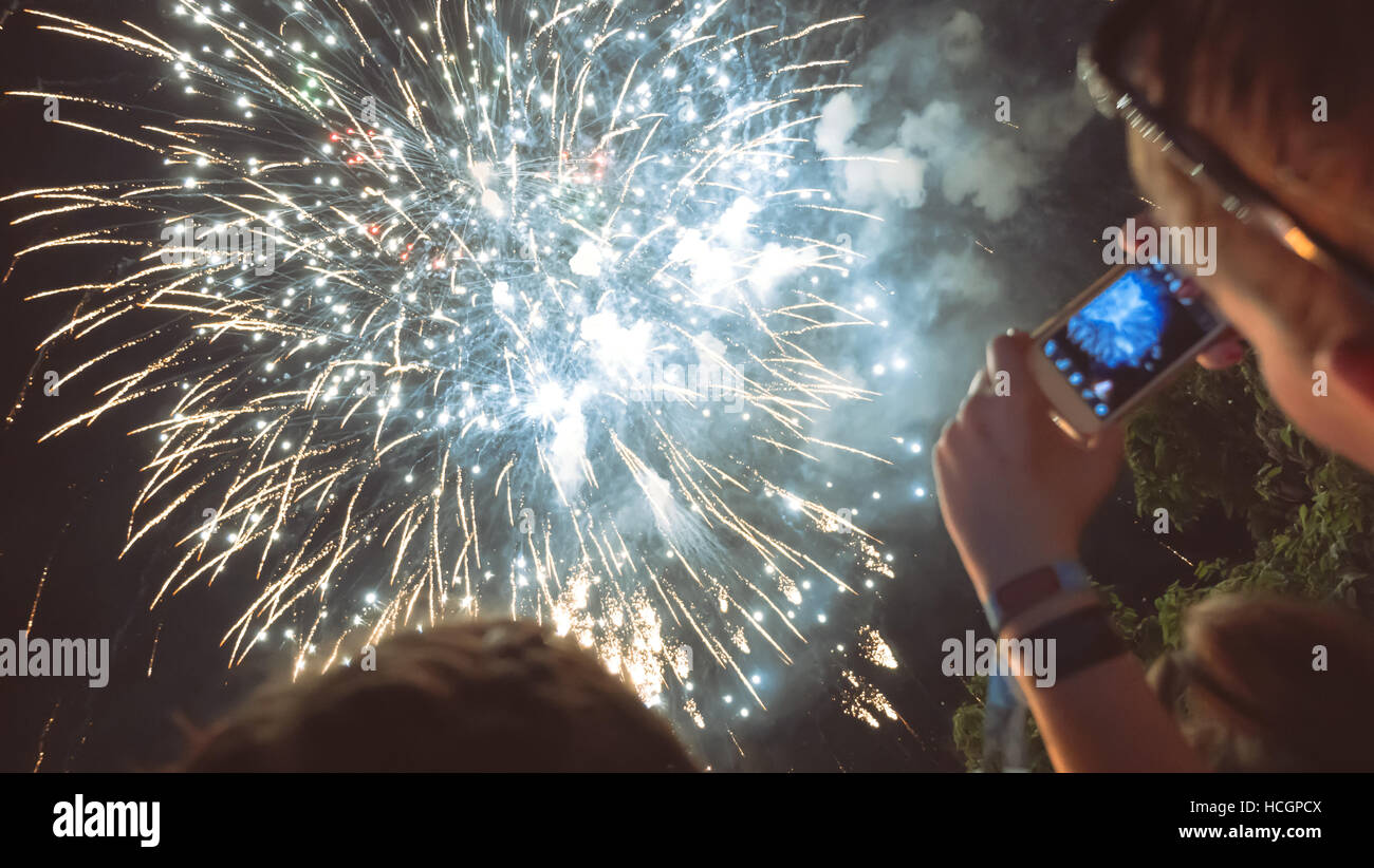Woman enjoying fireworks celebration and taking photos Stock Photo - Alamy