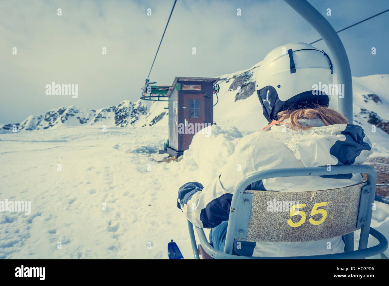 Back view of skier riding a lift Stock Photo - Alamy