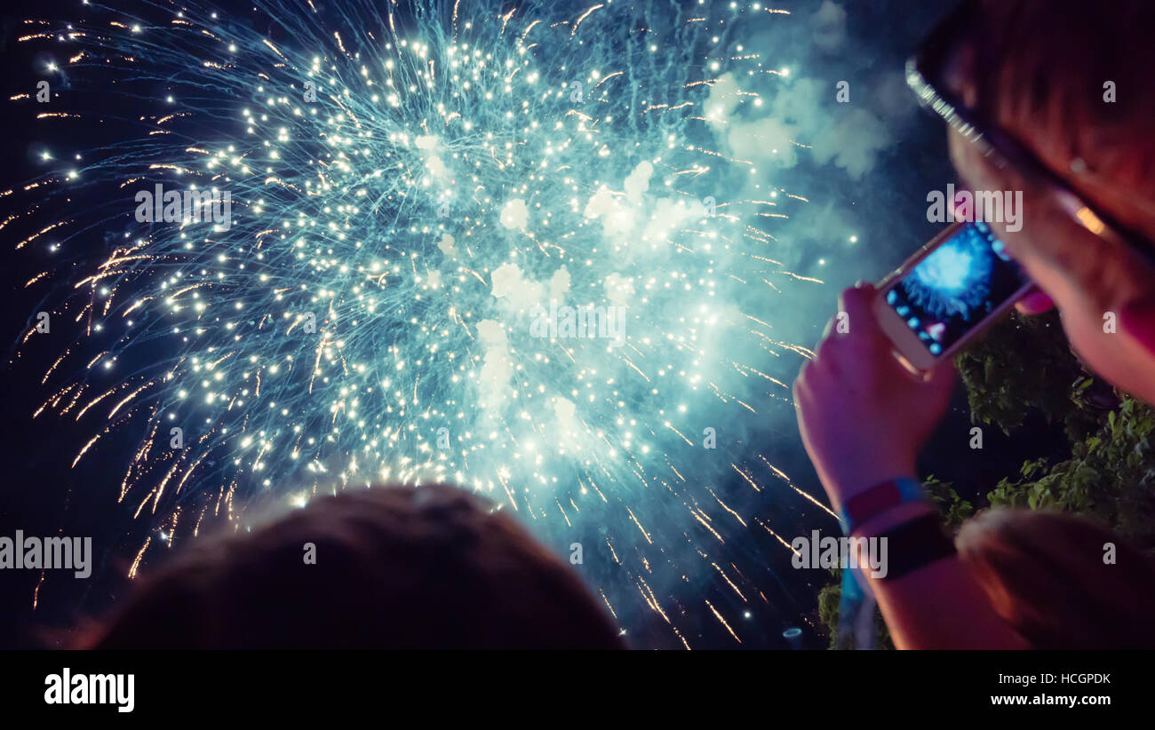 Woman photographing fireworks celebration with phone Stock Photo - Alamy