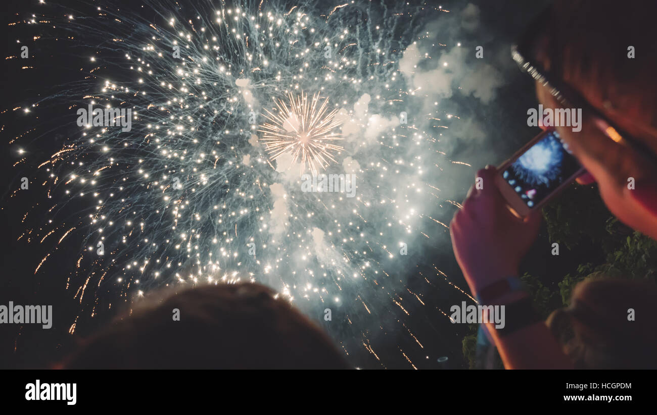 Woman enjoying fireworks celebration and taking photos Stock Photo - Alamy