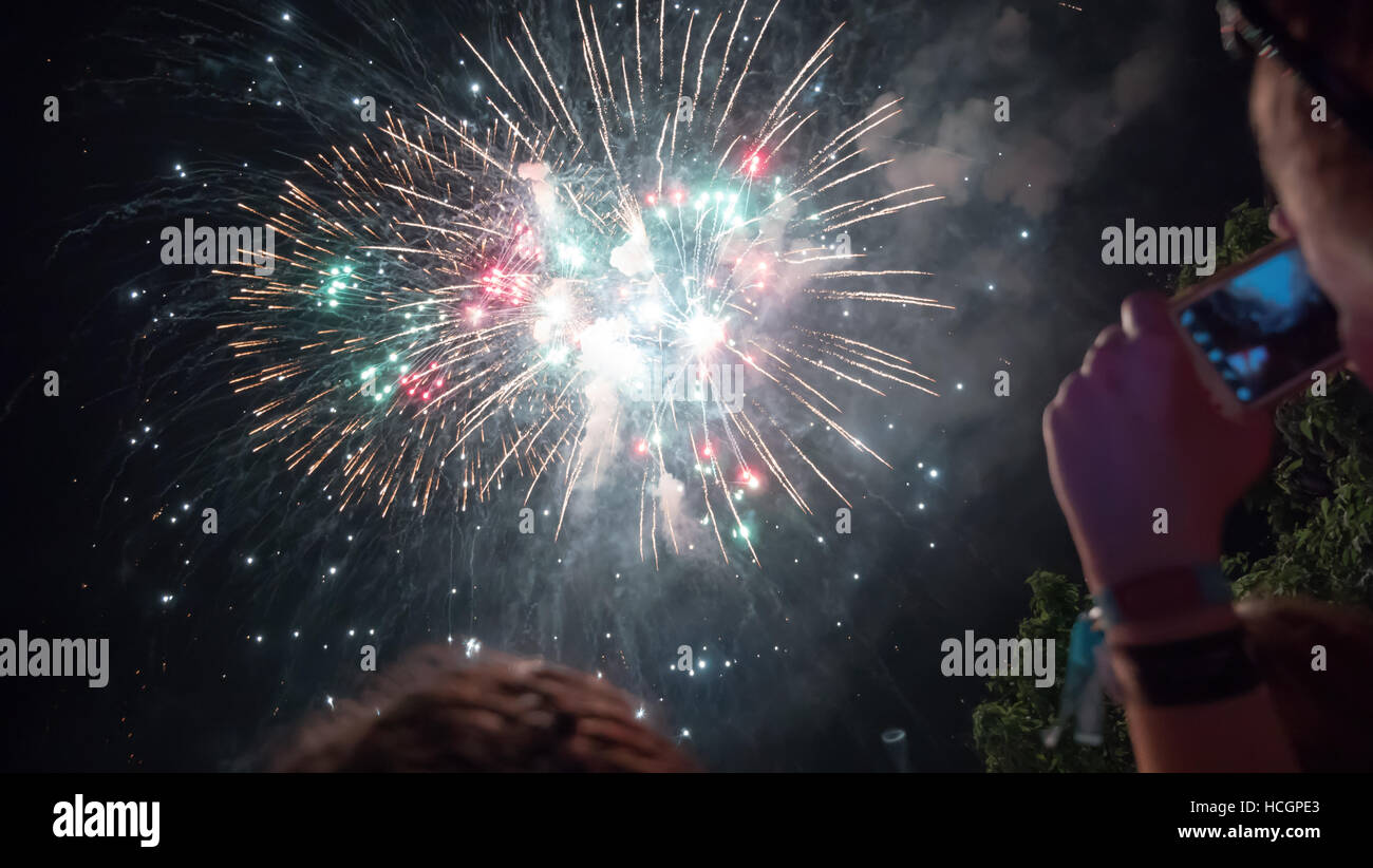 Woman enjoying fireworks celebration and taking photos Stock Photo - Alamy