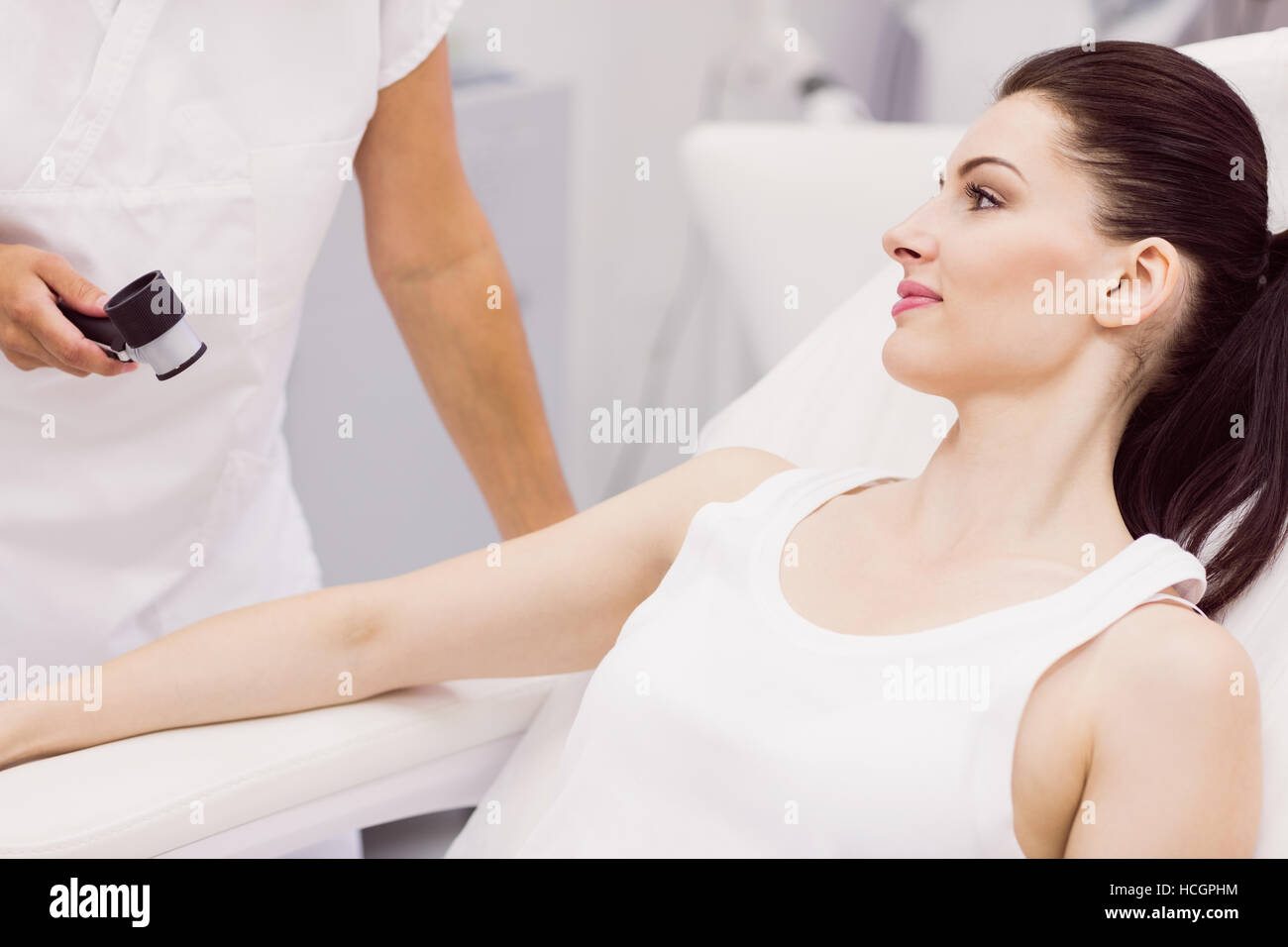 Dermatologist examining skin of patient with dermatoscope Stock Photo ...