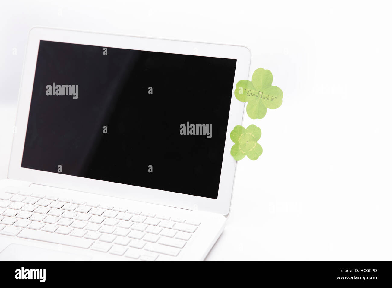 Notebook computer with four-leaf clovers Stock Photo - Alamy