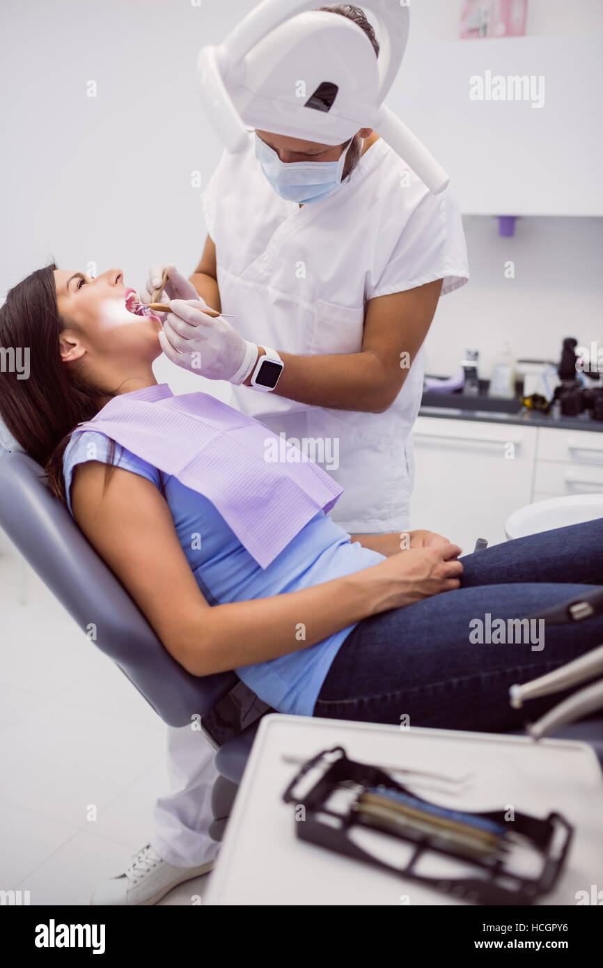 Dentist examining female patient teeth Stock Photo - Alamy