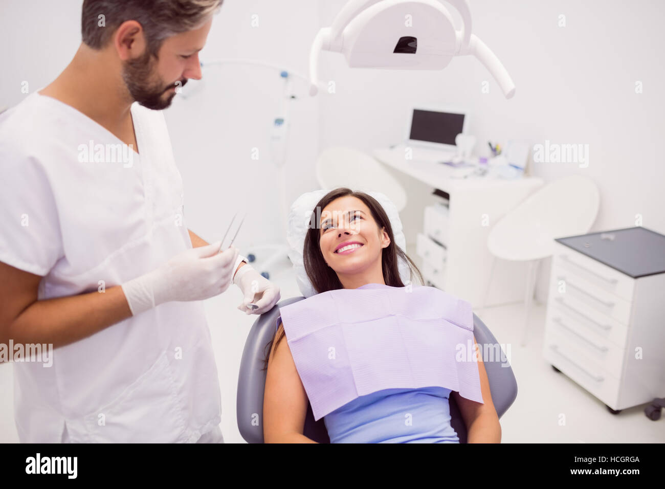Dentist with smiling female patient Stock Photo - Alamy