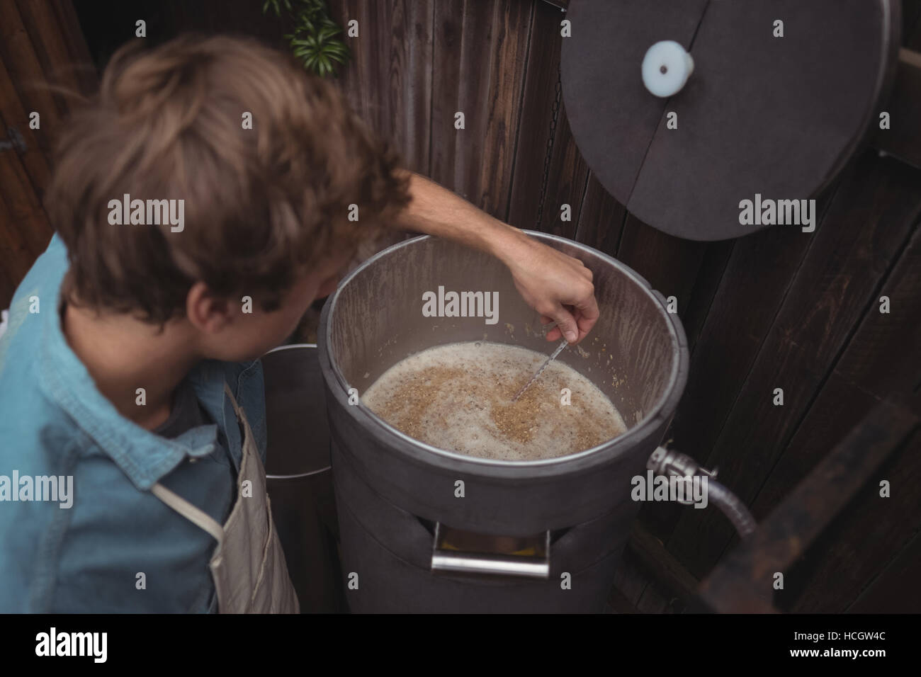 Man testing temperature of beer in wort while making beer Stock Photo ...