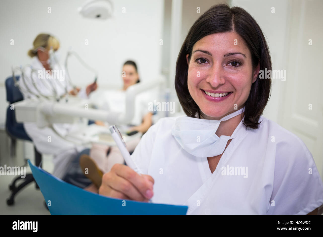 Female dentist writing report in dental clinic Stock Photo - Alamy
