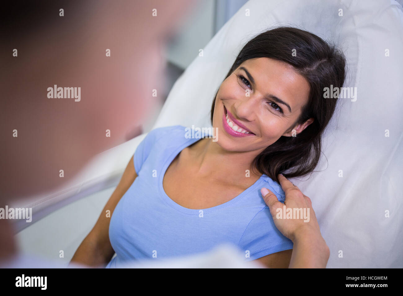 Female patient smiling while talking to doctor Stock Photo - Alamy