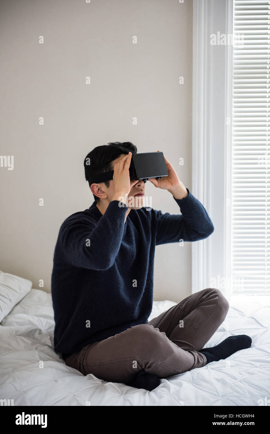 Man using virtual reality headset in bedroom Stock Photo - Alamy