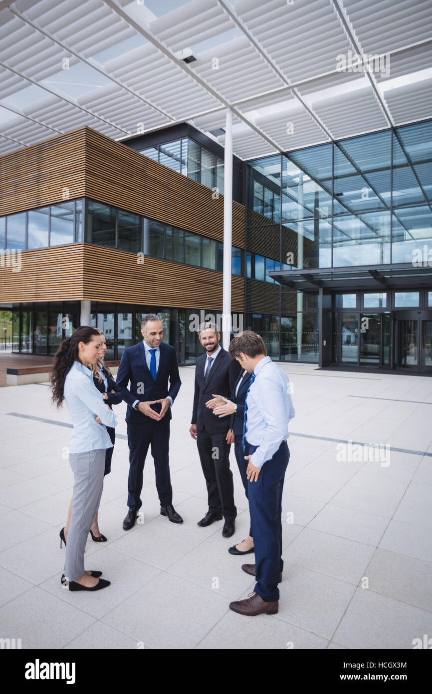 Group of businesspeople interacting outside office building Stock Photo ...
