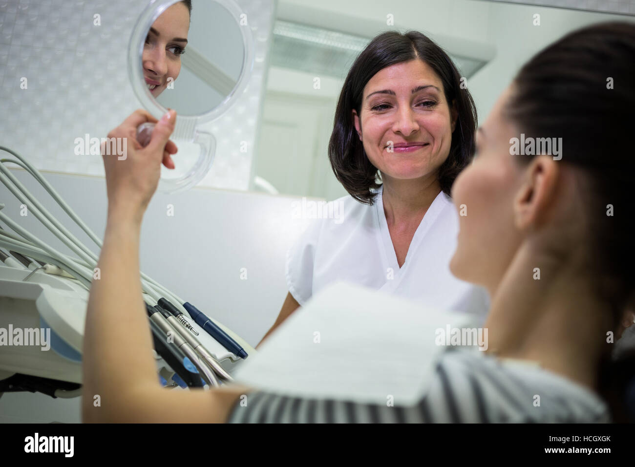 Patient checking her teeth in mirror Stock Photo - Alamy