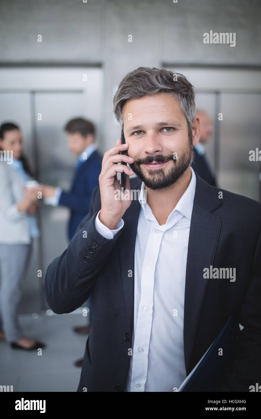 Confident businessman using smartphone holding hi-res stock photography ...