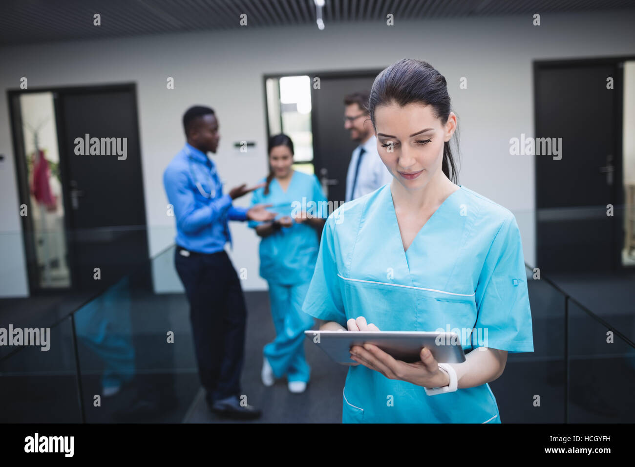 Nurse using digital tablet in hospital corridor Stock Photo - Alamy