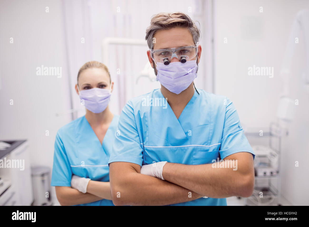 Dentist standing with arms crossed at dental clinic Stock Photo - Alamy