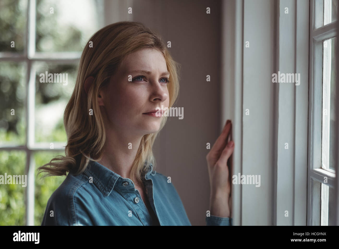 Thoughtful woman looking through window Stock Photo - Alamy Thoughtful woman looking through window Stock Photo - Alamy