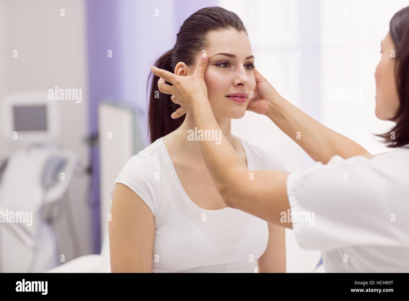 Dermatologist examining female patient skin Stock Photo - Alamy