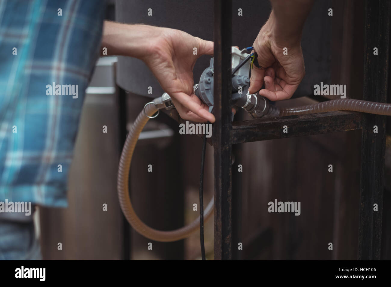 Man fixing pipe to beer wort to make beer Stock Photo - Alamy