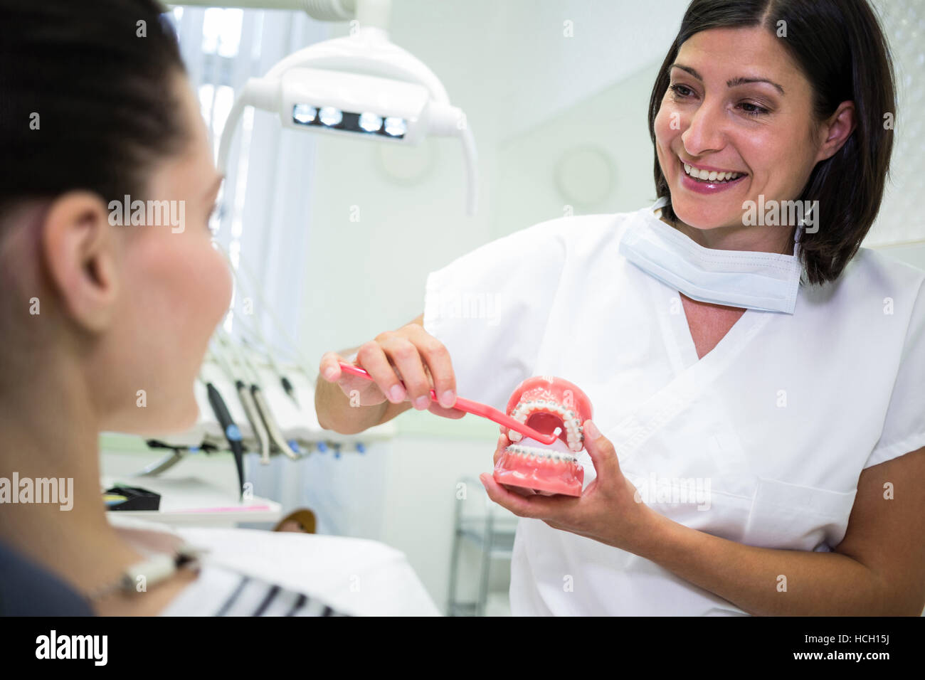 Dentist showing patient how to brush teeth Stock Photo - Alamy