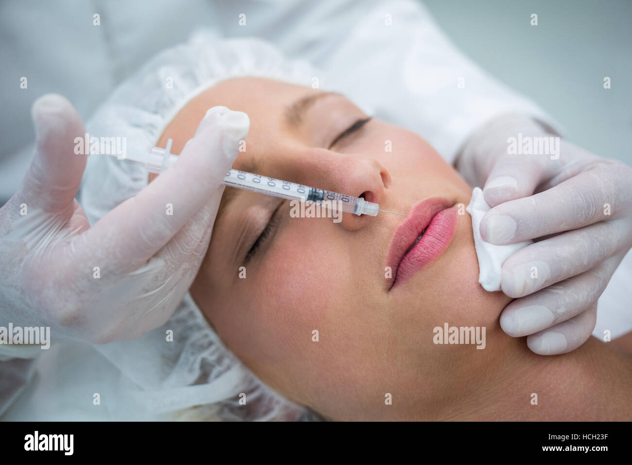 Female patient receiving a botox injection on lips Stock Photo - Alamy