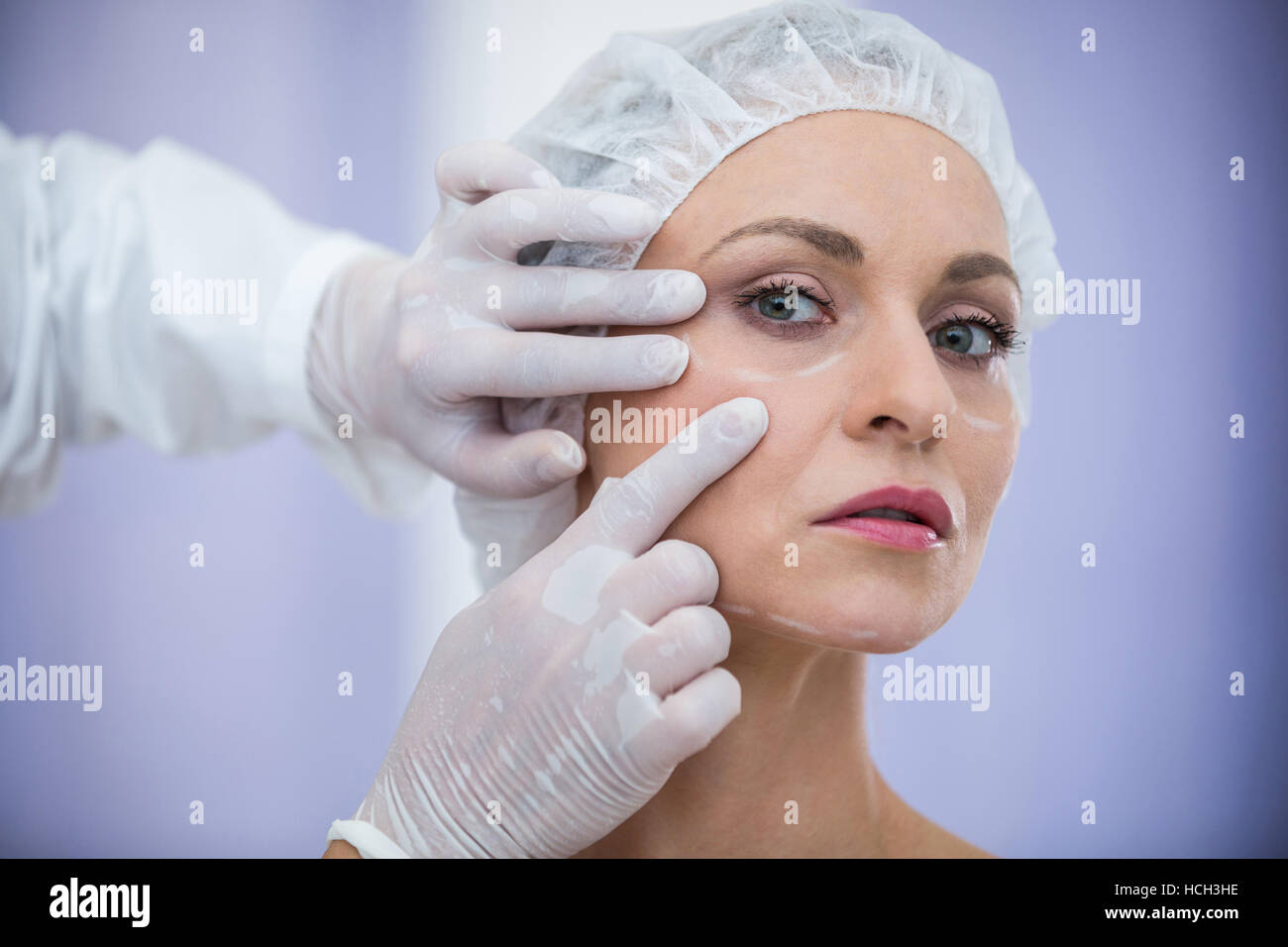 Doctor examining female patients face for cosmetic treatment Stock ...