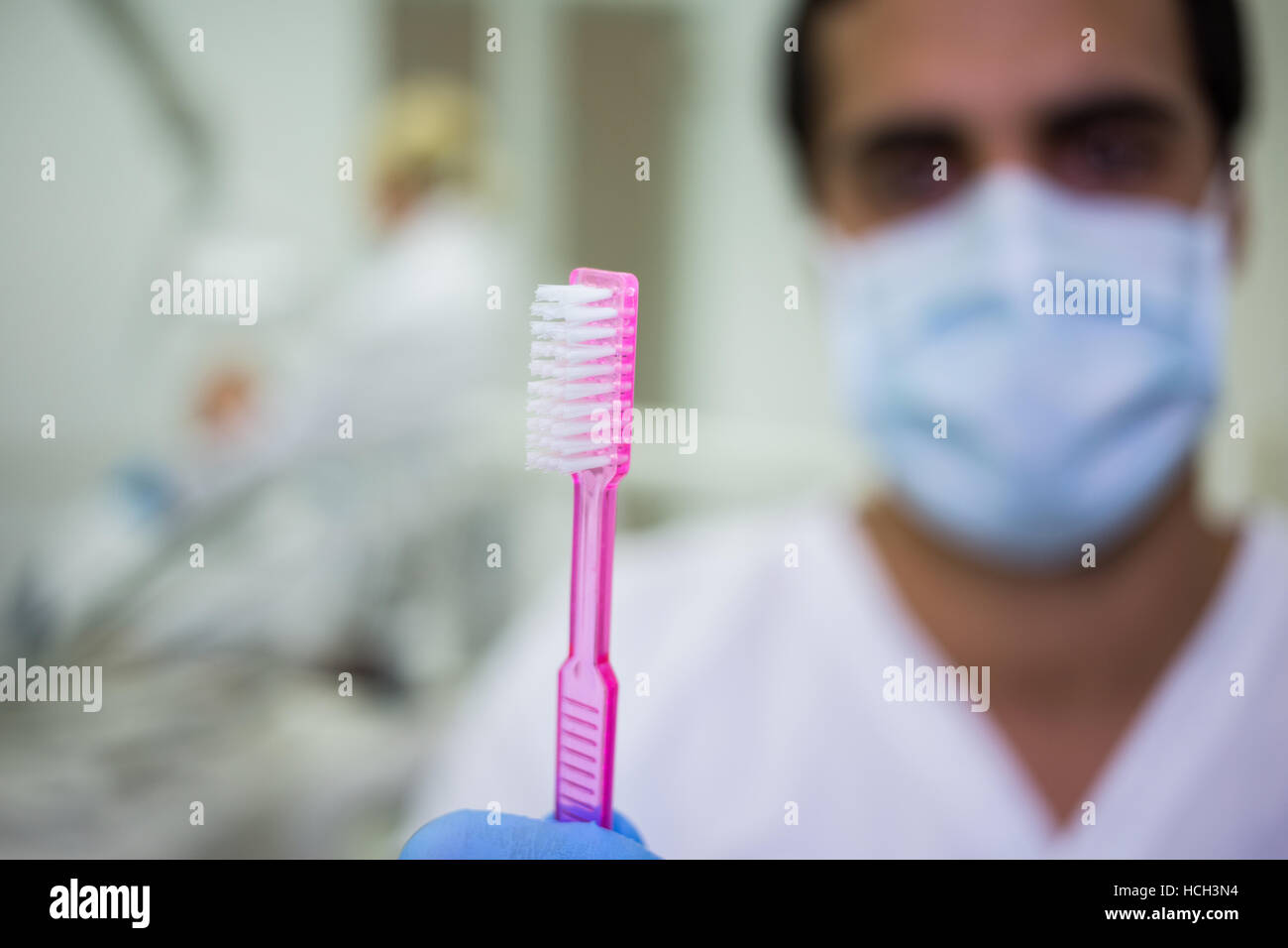 Dentist showing toothbrush Stock Photo - Alamy