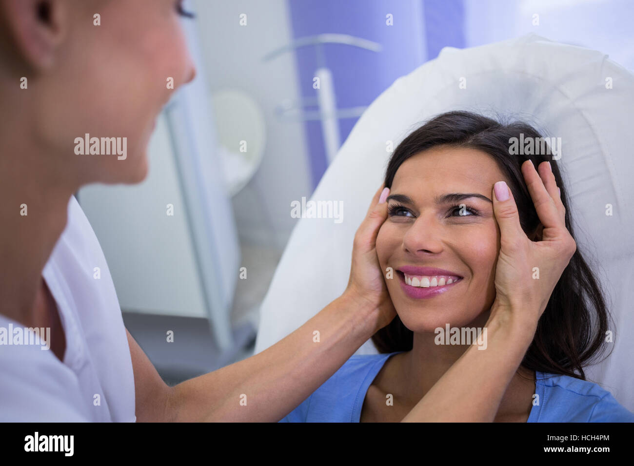 Doctor examining female patients face at clinic Stock Photo - Alamy