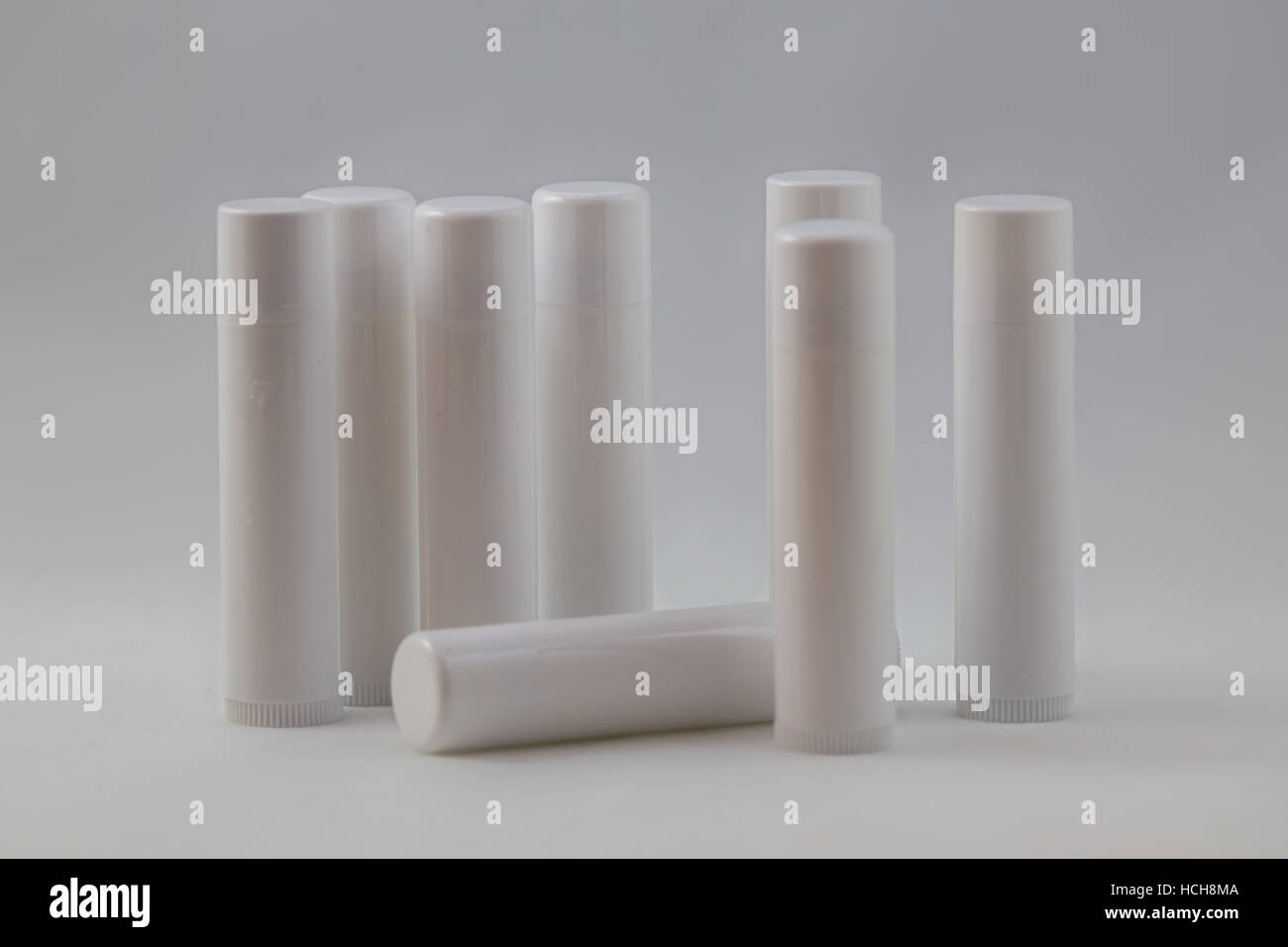 Arrangement of many white chapstick shaped tubes on a white background ...